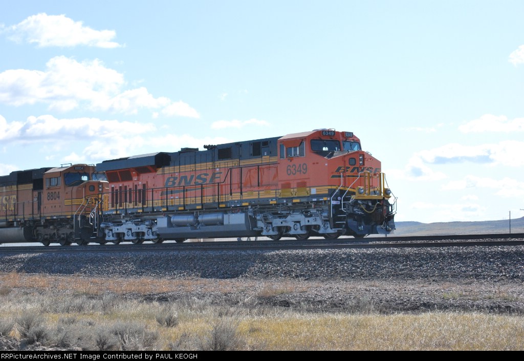 BNSF 6349 in the shade shot shows how new and clean she is as she rolls east as rear DPU unit on ...